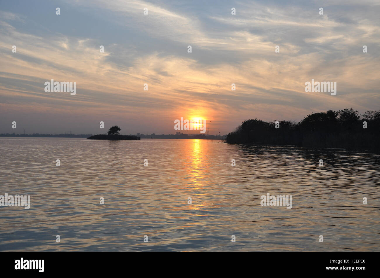 Sunset at the lake,Setting sun at the tranquil lake with clouds and ...
