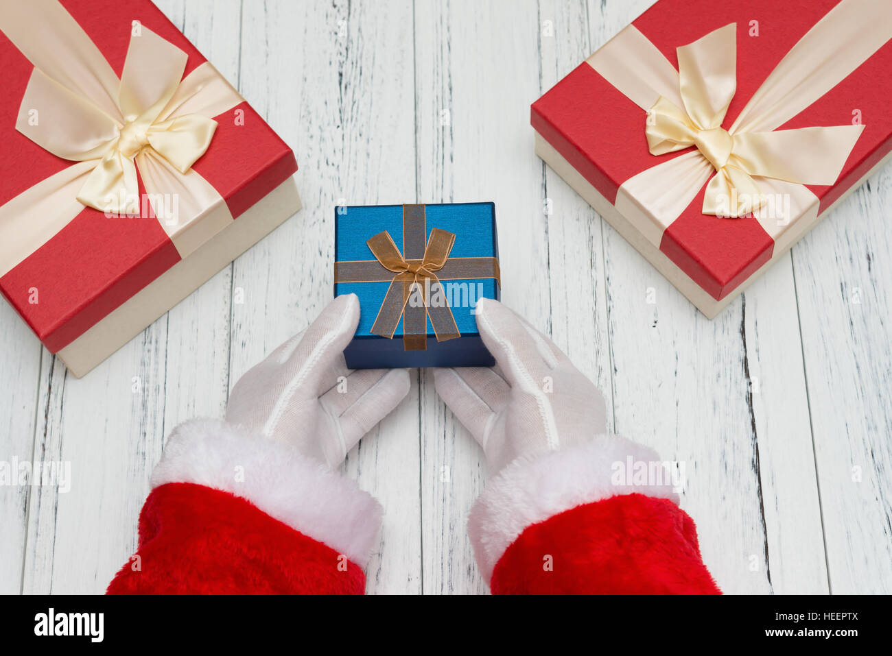 Santa Claus handing a Christmas Gift box over wood background Stock ...