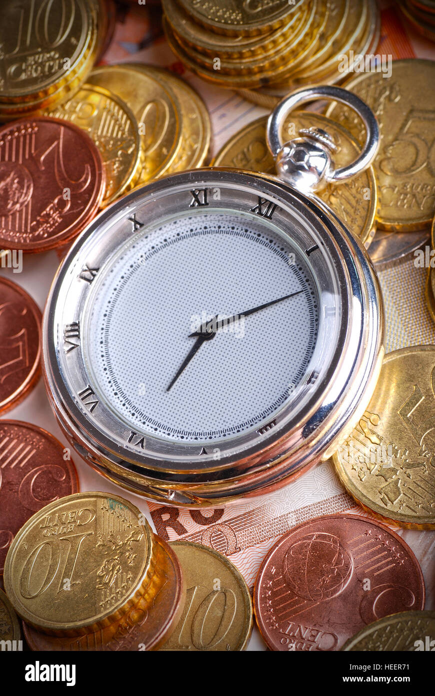 money and time - clock and euro coins closeup Stock Photo - Alamy