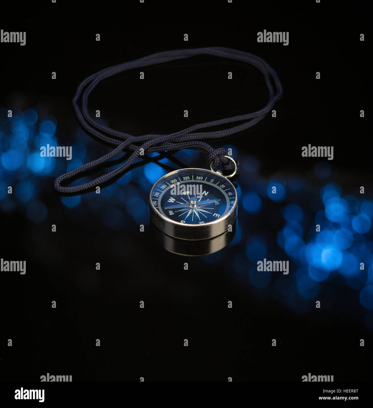 Compass on dark background with blue defocused lights Stock Photo - Alamy