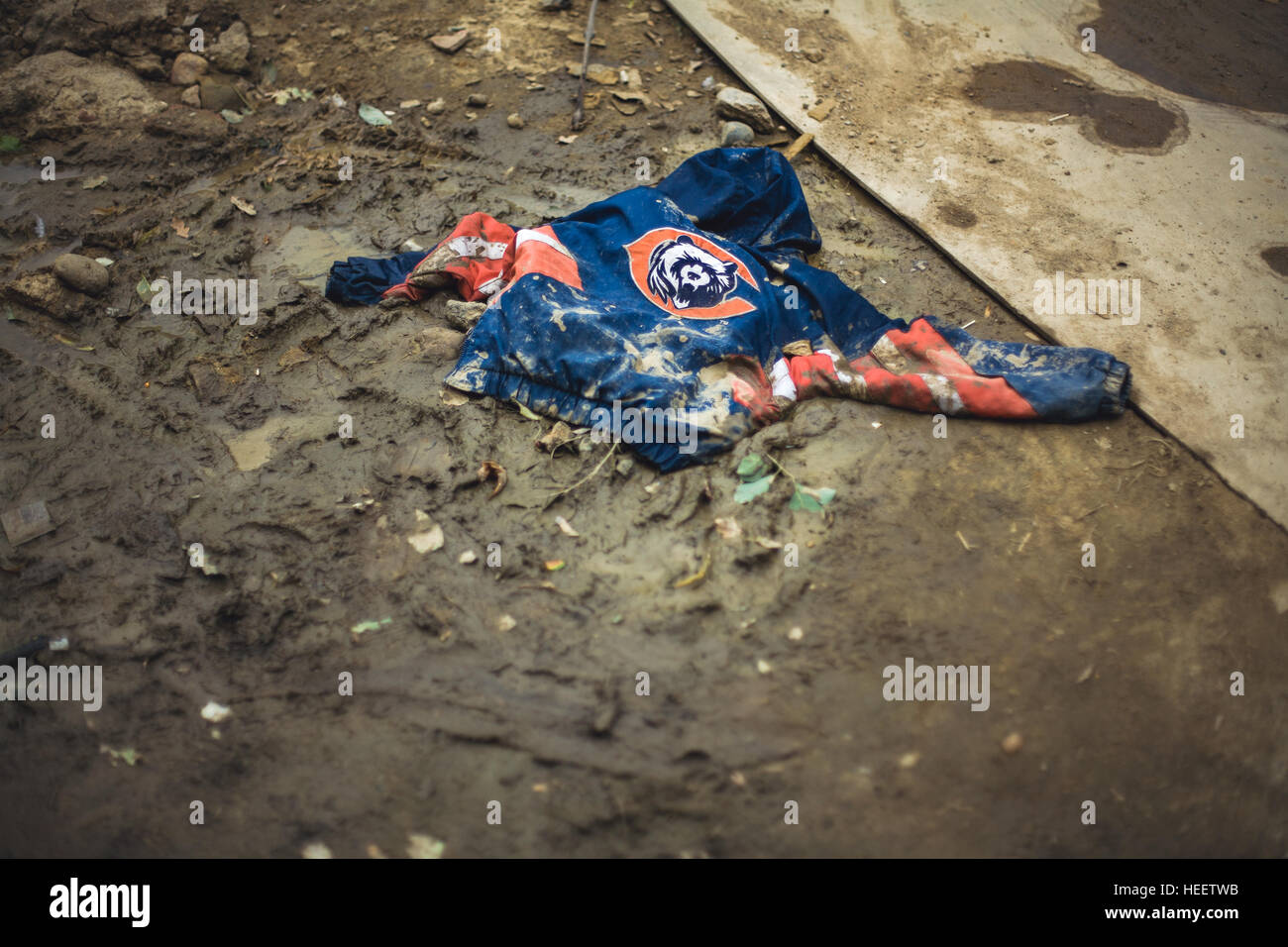 Muddy blue sport jacket dropped in to brown mud Stock Photo - Alamy