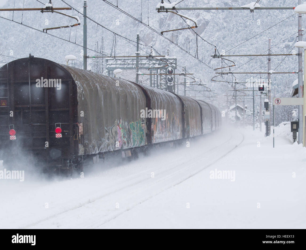 back view of a Freight train running on the railway tracks in winter ...