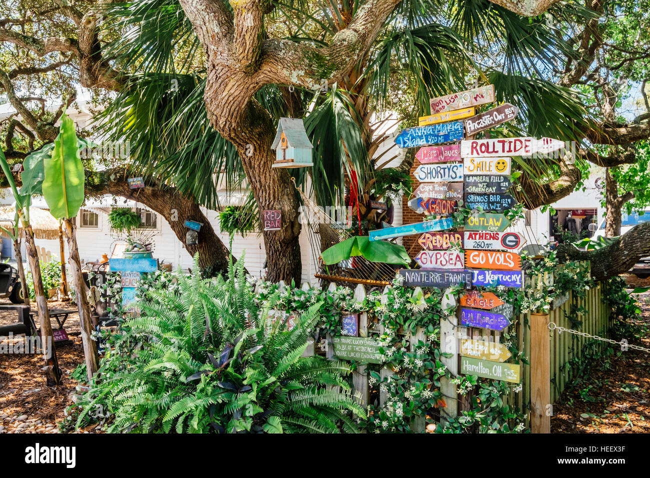 Colorful and funny directional signs in front of a small beach home at ...
