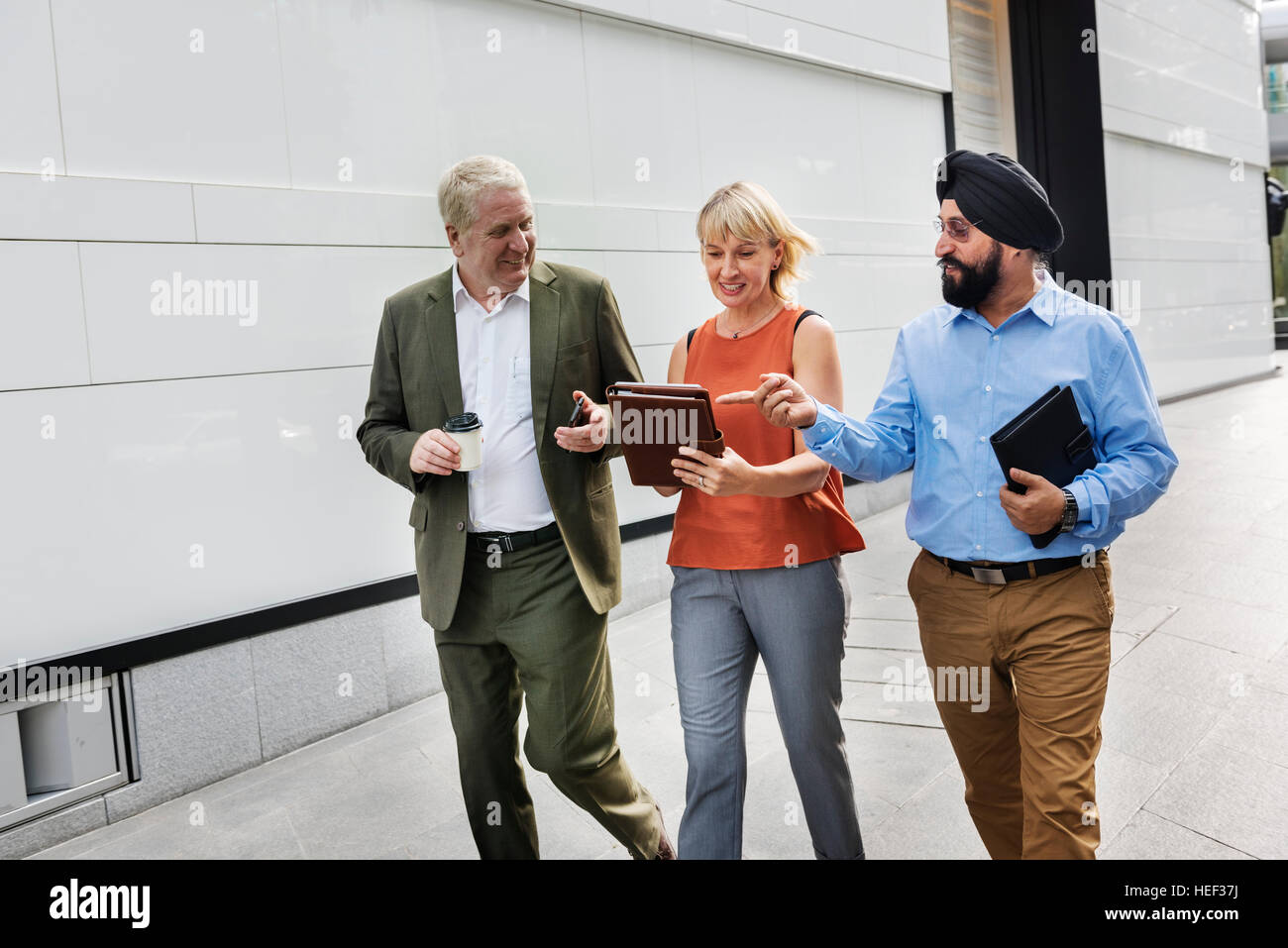 Multiethnic male colleagues walking outdoors hi-res stock photography ...