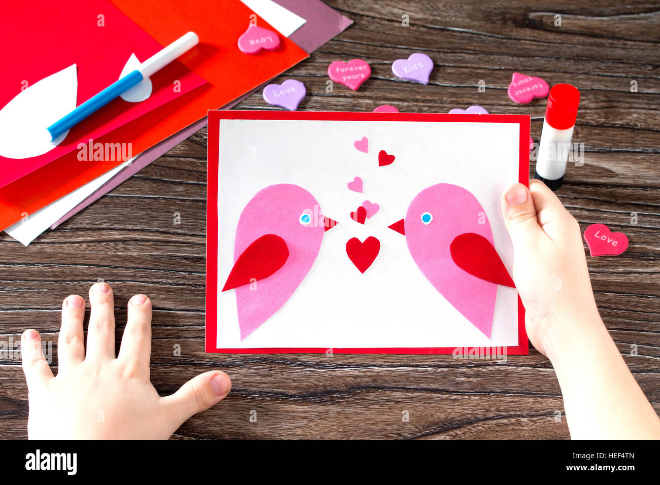 The child hold birthday card two birds and hearts from paper Valentine ...