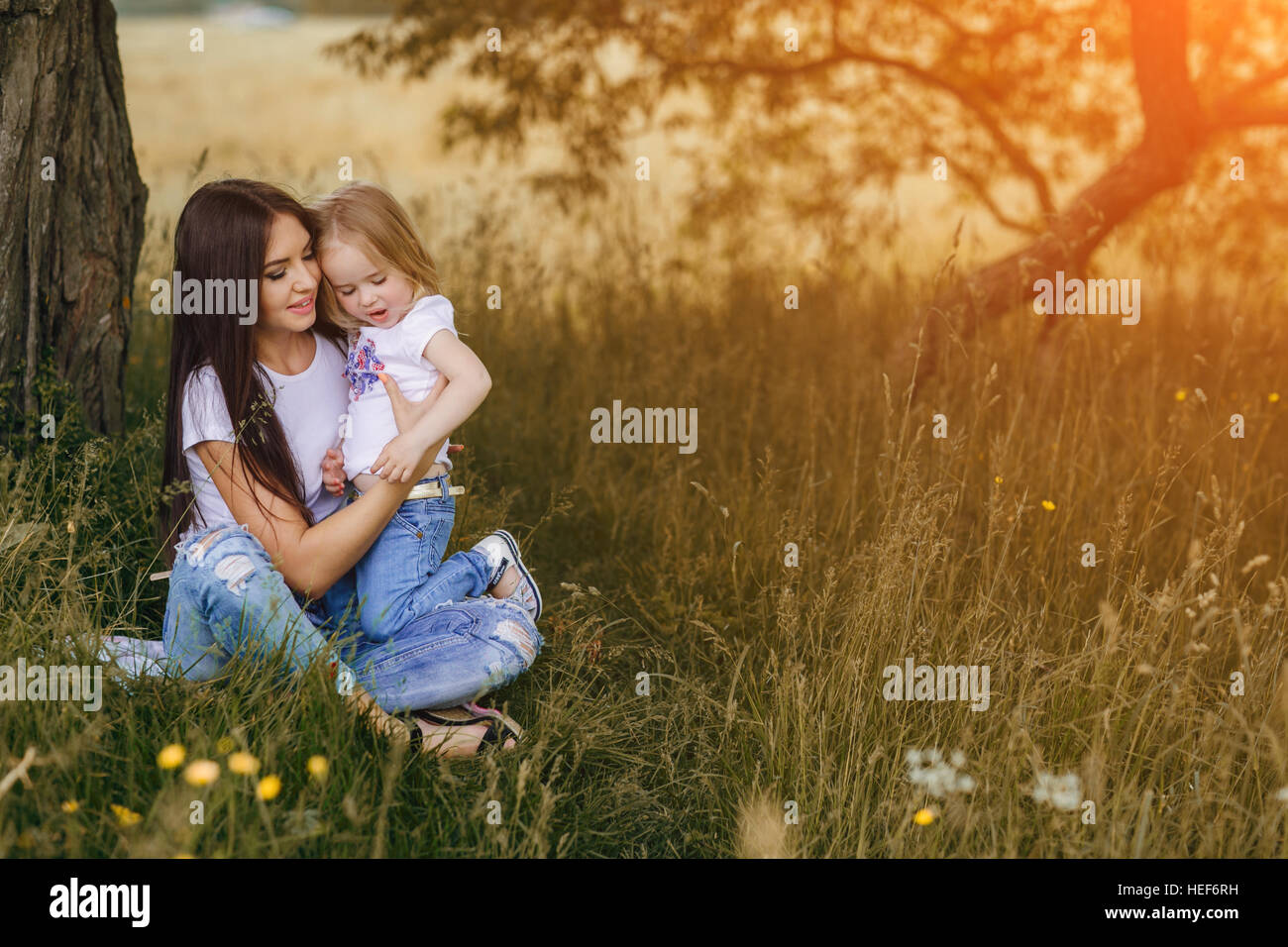 child near tree with mom Stock Photo - Alamy