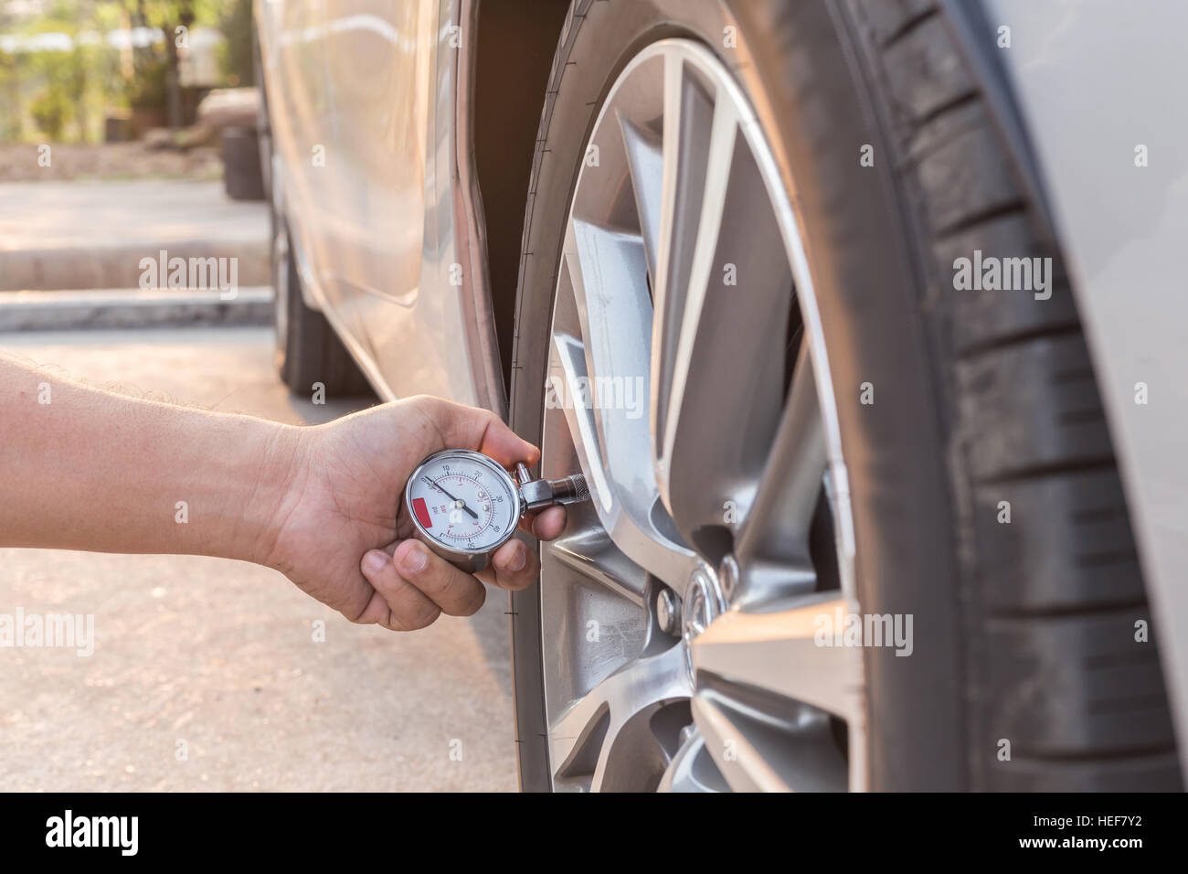 Man holding pressure gauge and checking air pressure of his car Stock ...
