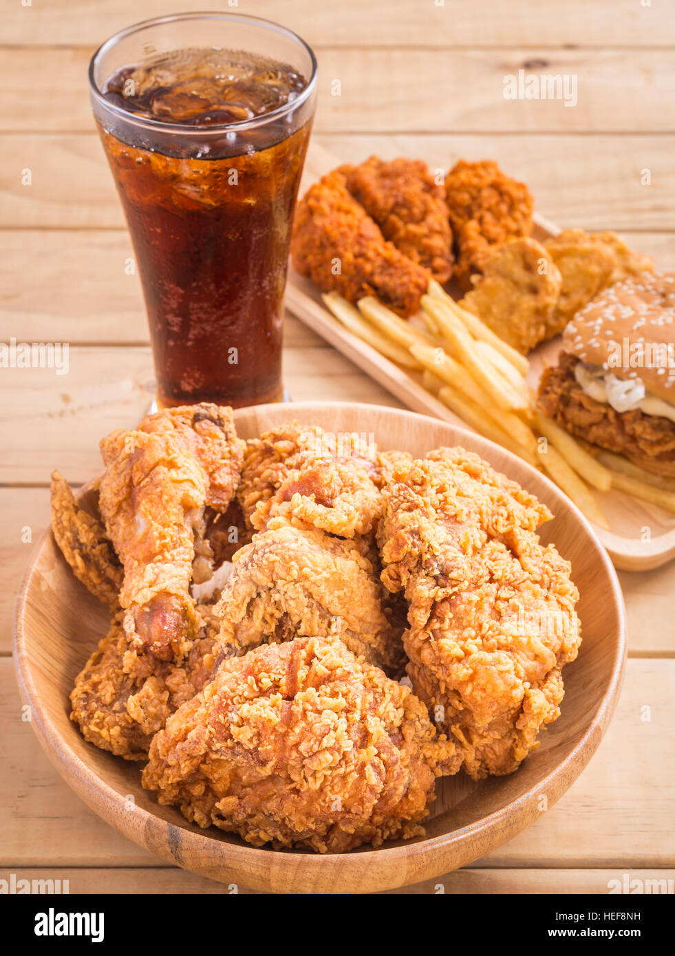 Close up fried chicken, french fries and soft drink on wooden table ...