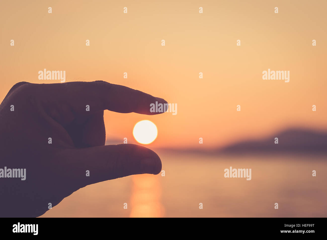 Silhouette of hand with sign on sun at the sunset time Stock Photo - Alamy