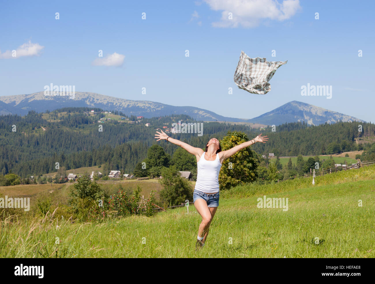 Beautiful girl throwing her clothes at grass meadow Stock Photo - Alamy