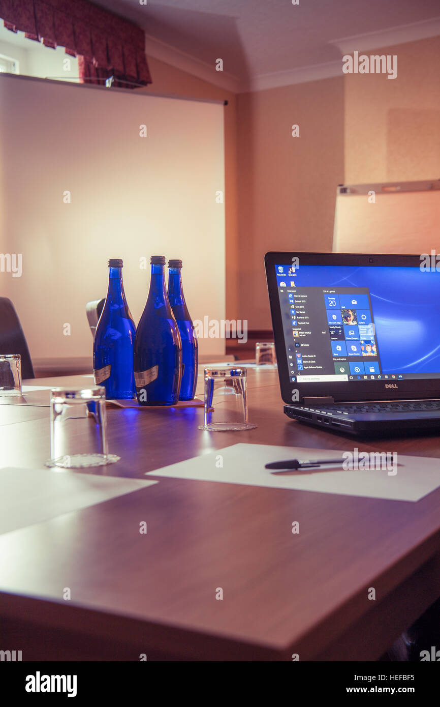 A laptop computer and blue bottles of Ty Nant mineral water on the ...