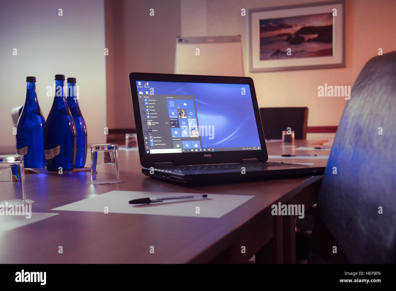 A laptop computer and blue bottles of Ty Nant mineral water on the ...