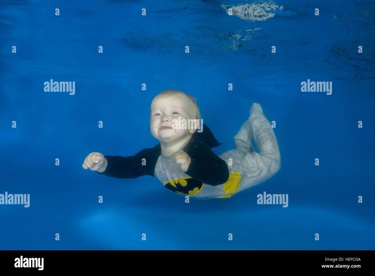 Little boy in a Batman costume posing under the water in the pool Stock ...