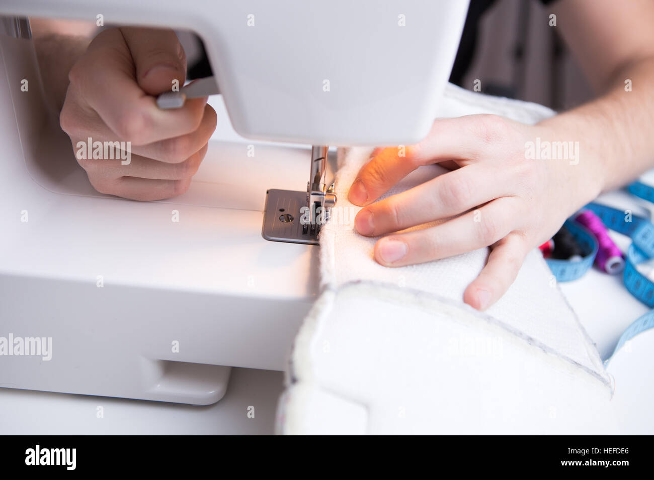 Young girl stitching white cloth Stock Photo - Alamy