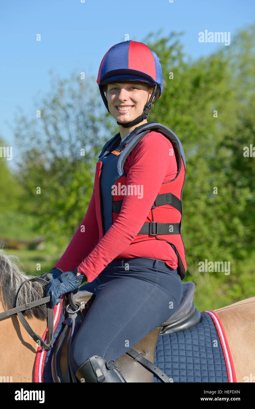 Young rider on back of a Norwegian Fjord horse wearing a body protector ...