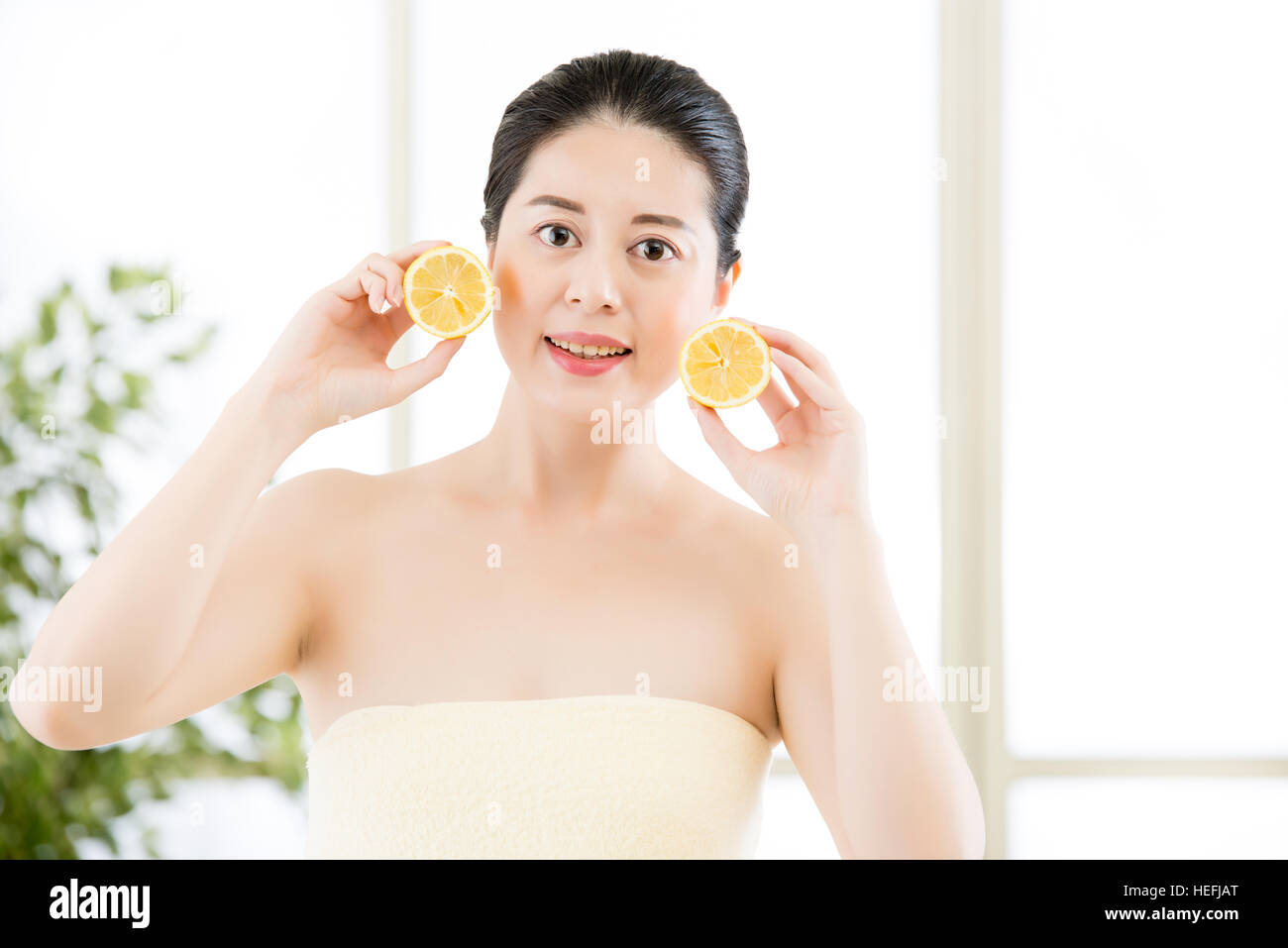 Beautiful asian woman holding slices of lemon. Lemon for beauty and ...