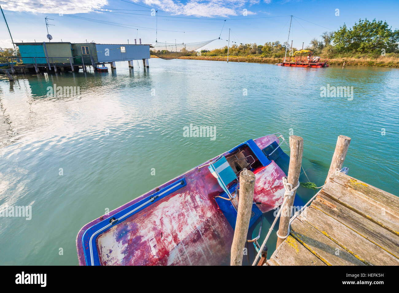 sunken boat and fishing huts on brackish lagoon in Italy Stock Photo ...