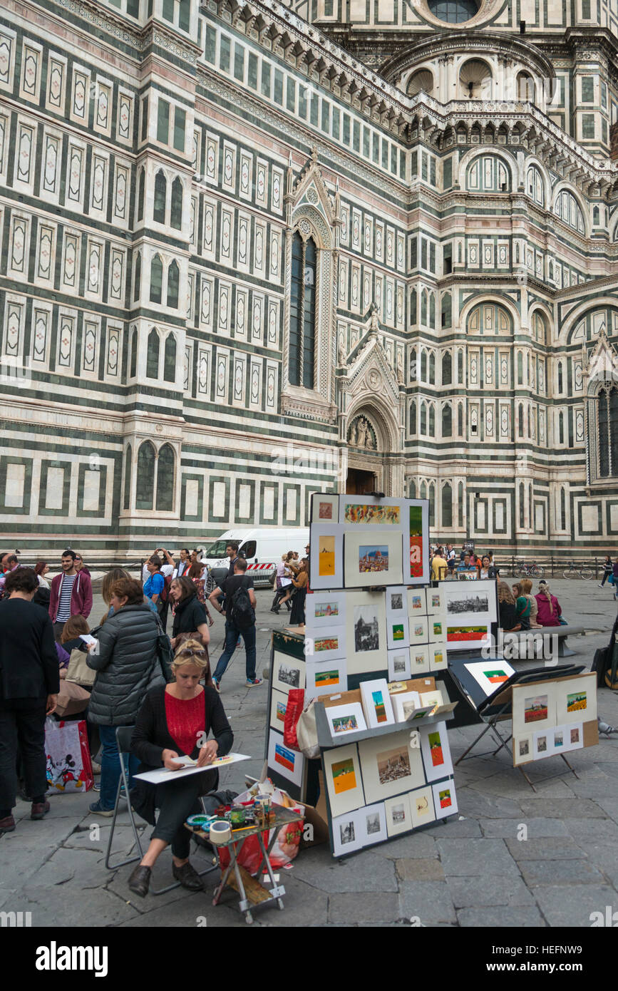 Woman with display of paintings for sale in front of Duomo Santa Maria ...