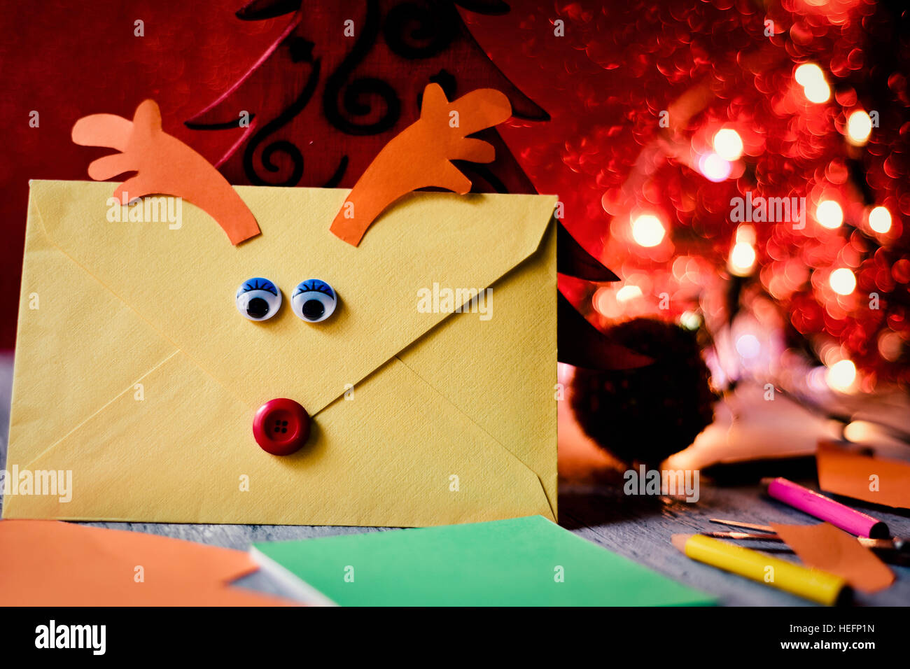 closeup of an envelope customized as a reindeer face with a button as ...