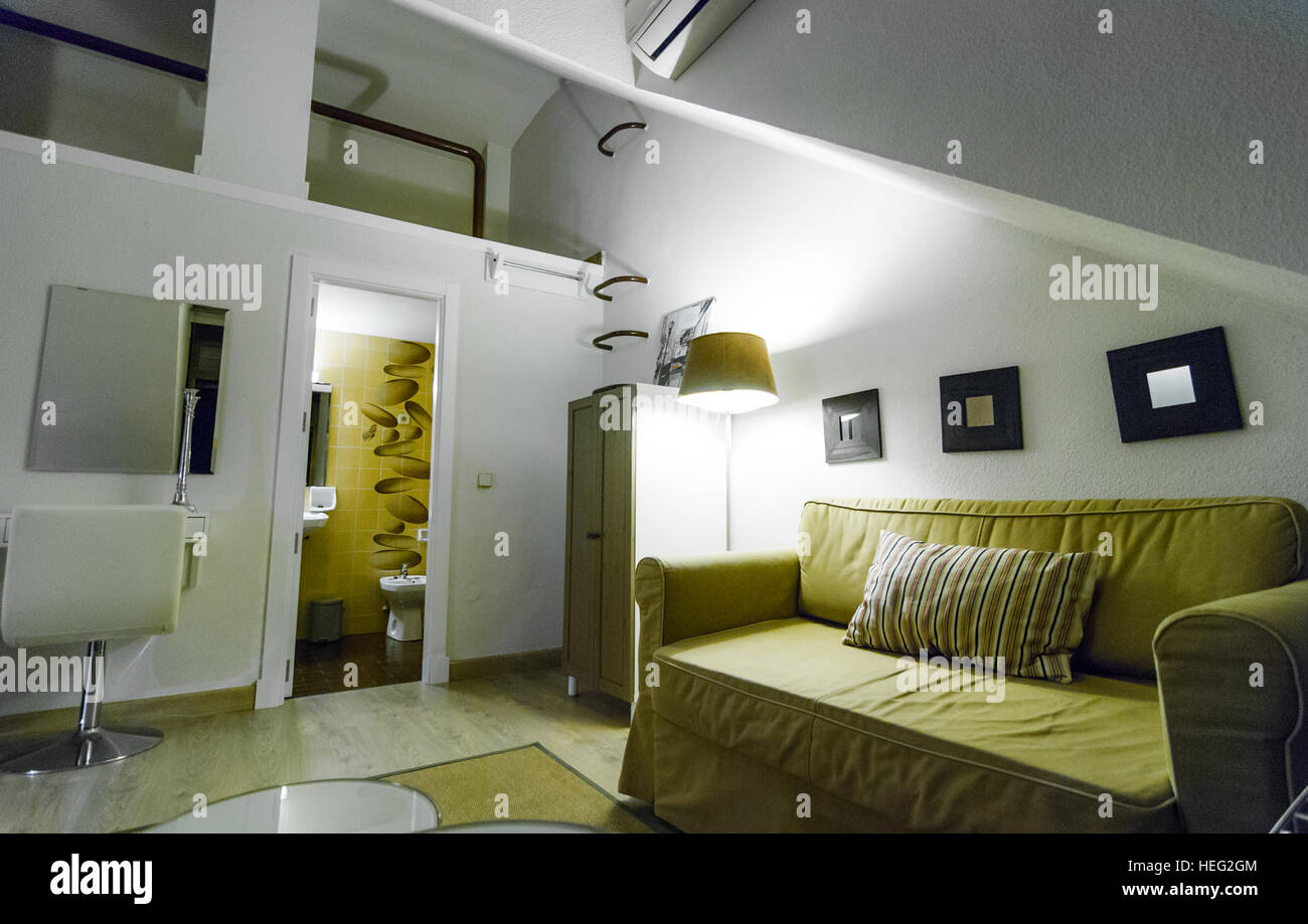 Simple modern sparsely decorated room with couch and water closet ...