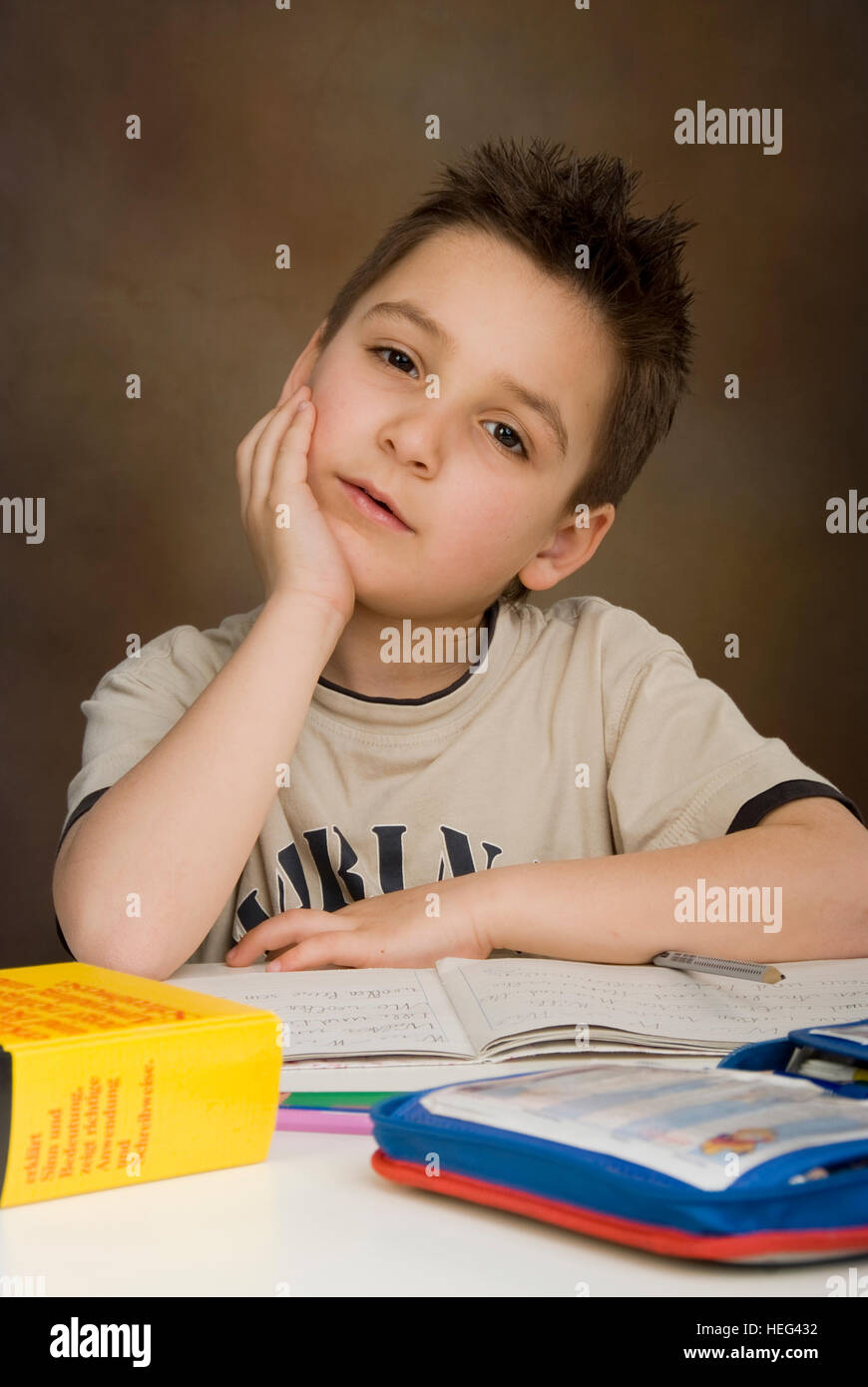 Seven-year-old schoolboy doing homework, looking bored Stock Photo - Alamy