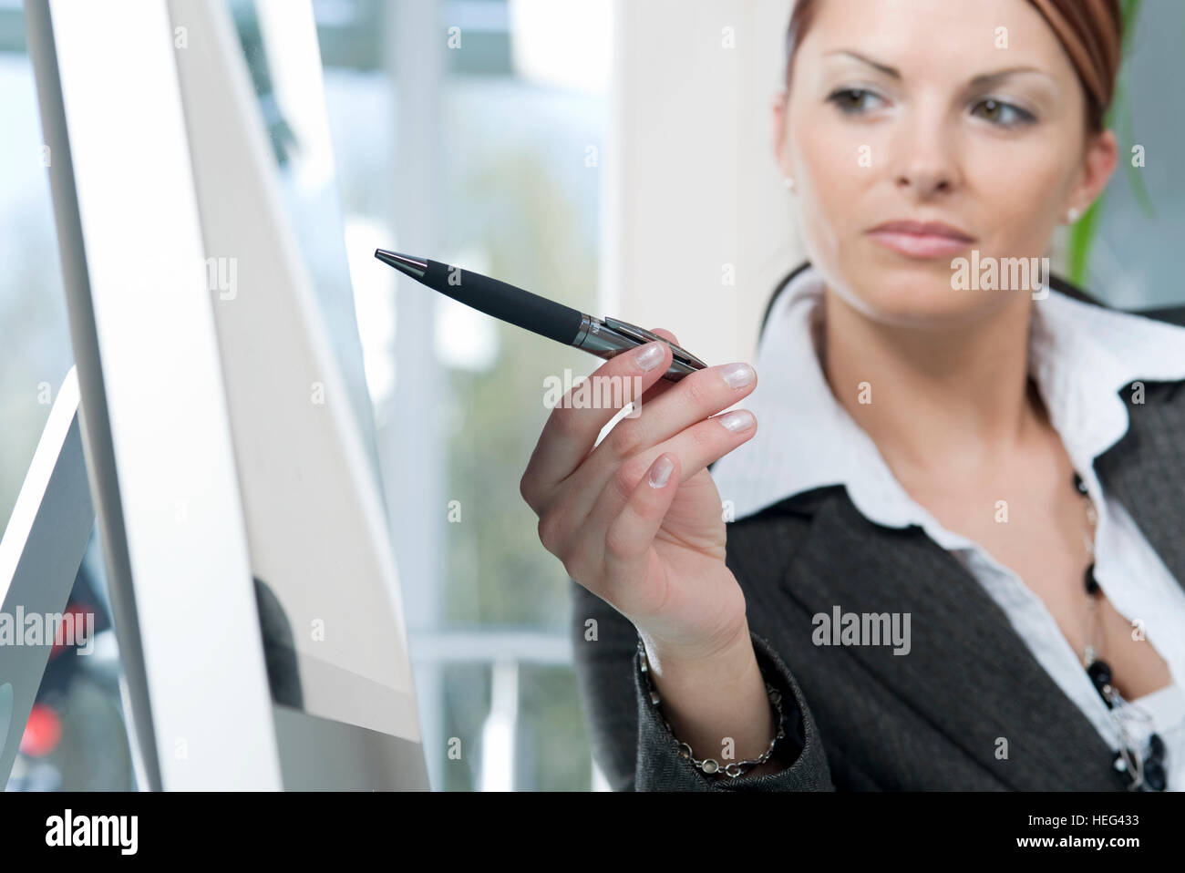 Young businesswoman pointing at a computer monitor, screen Stock Photo ...