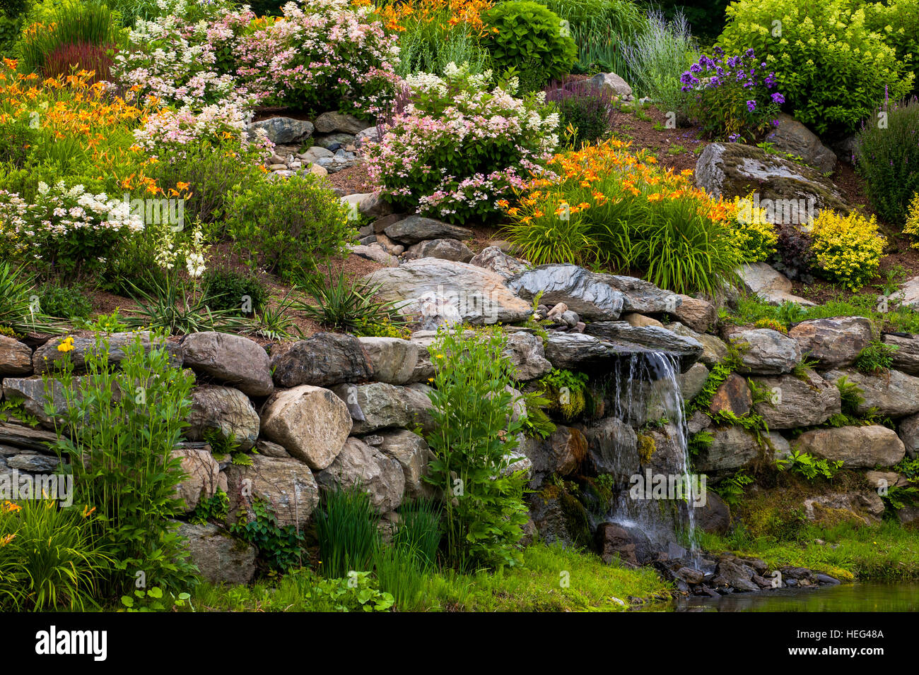 Rock Garden with flowers and small waterfall, Eastern Townships, Quebec ...