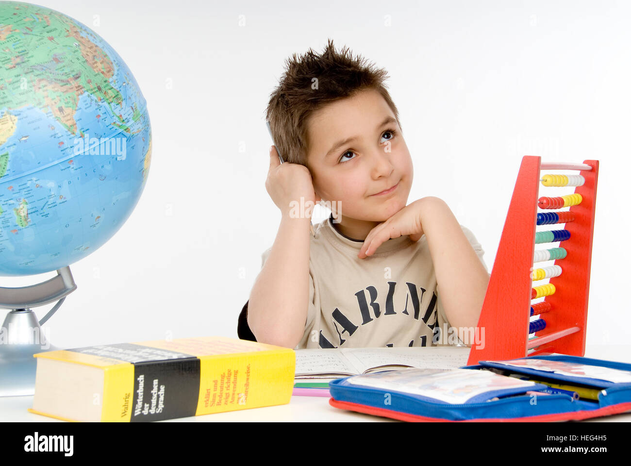Schoolboy, seven-year-old boy doing his homework, thinking Stock Photo ...