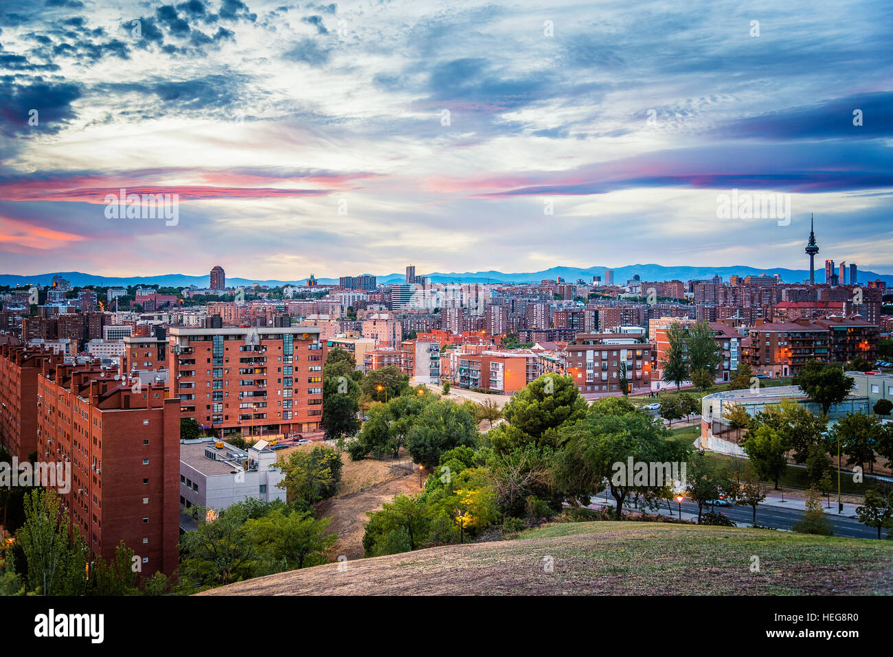 Madrid cityscape at dusk from a residential district and mountain range ...