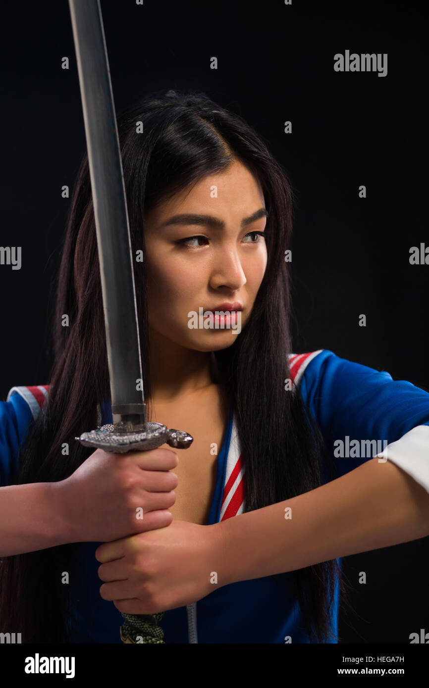 Asian lady with sword in studio Stock Photo - Alamy