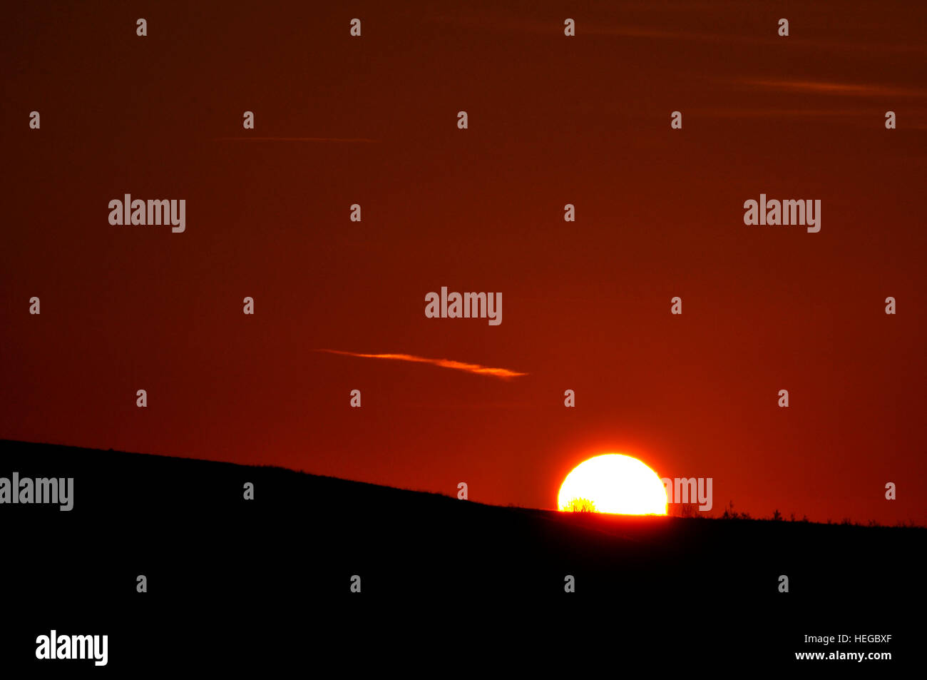 Sunset sinking below the horizon Stock Photo - Alamy
