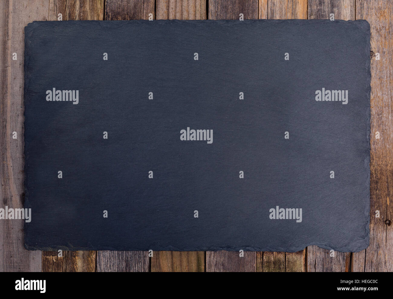 Black slate board over wooden background Stock Photo - Alamy