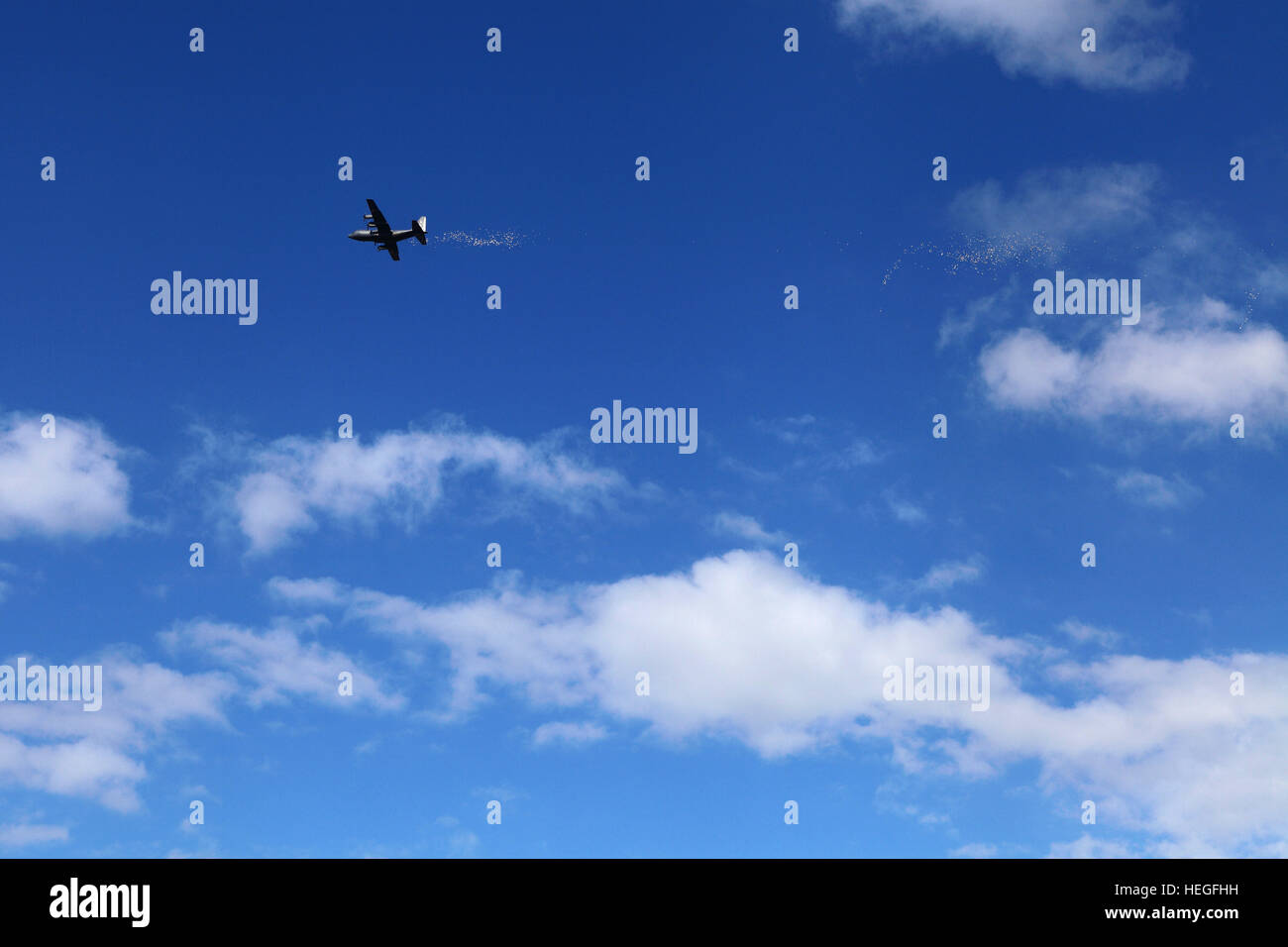 Transport plane spreading leaflets against blue cloudy sky Stock Photo ...