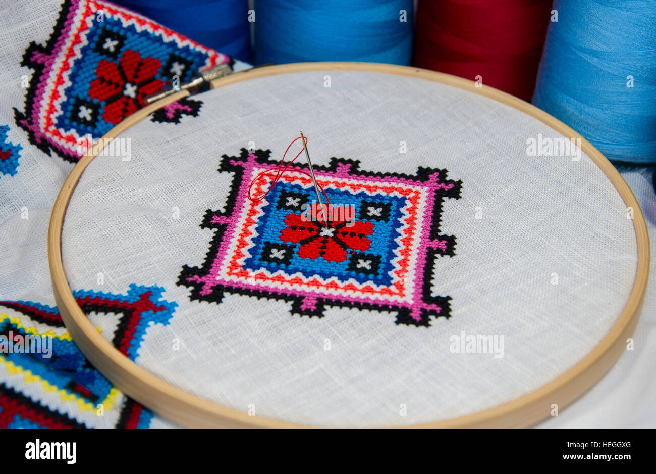 Traditional folk geometric pattern embroidered cross on a white cloth ...