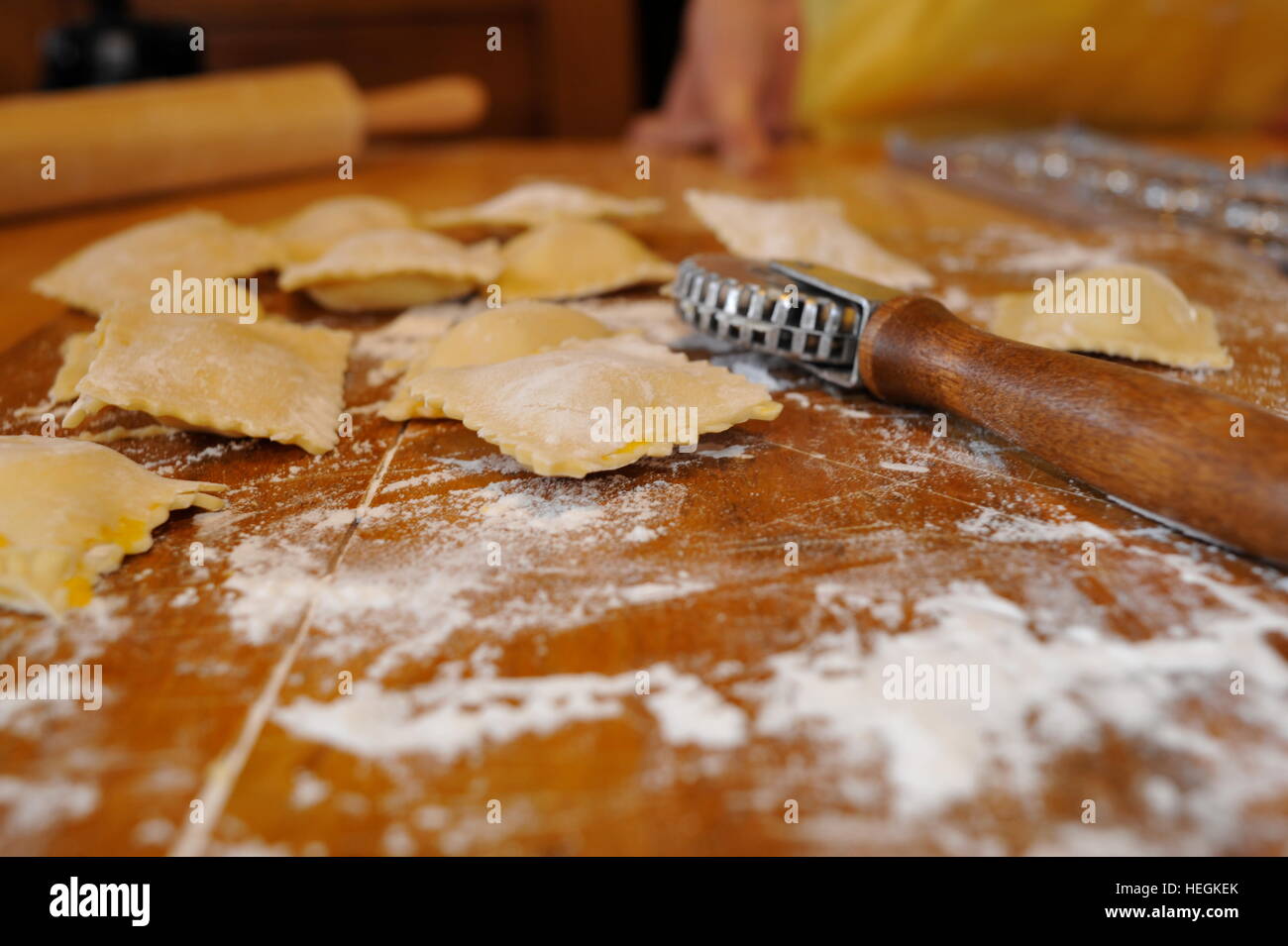 Making homemade ravioli with a pasta cutter in a kitchen, on floor ...