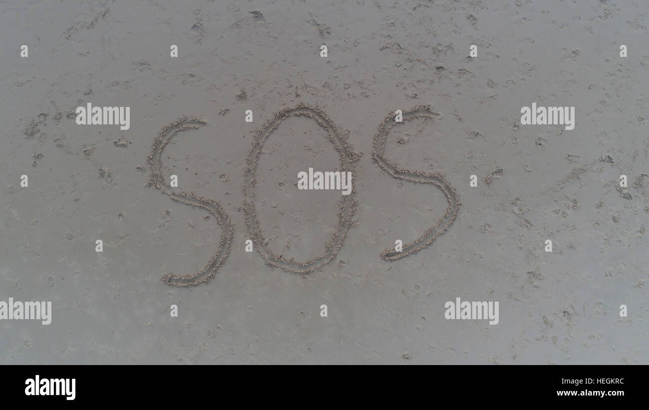 Top view photo of SOS written in sand on tropical beach. Concept photo ...