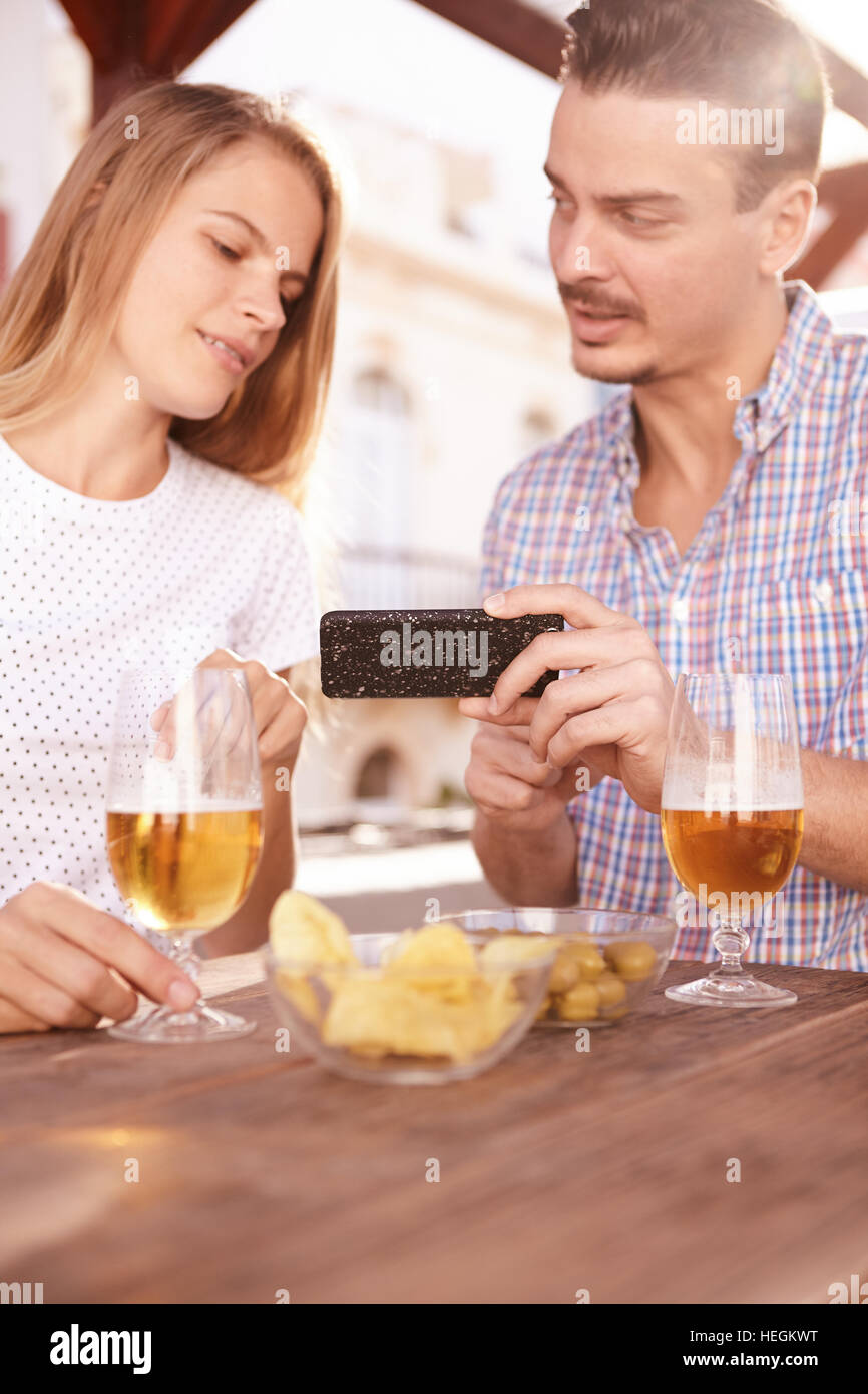 Handsome guy explaining something about his phone to a beautiful girl ...
