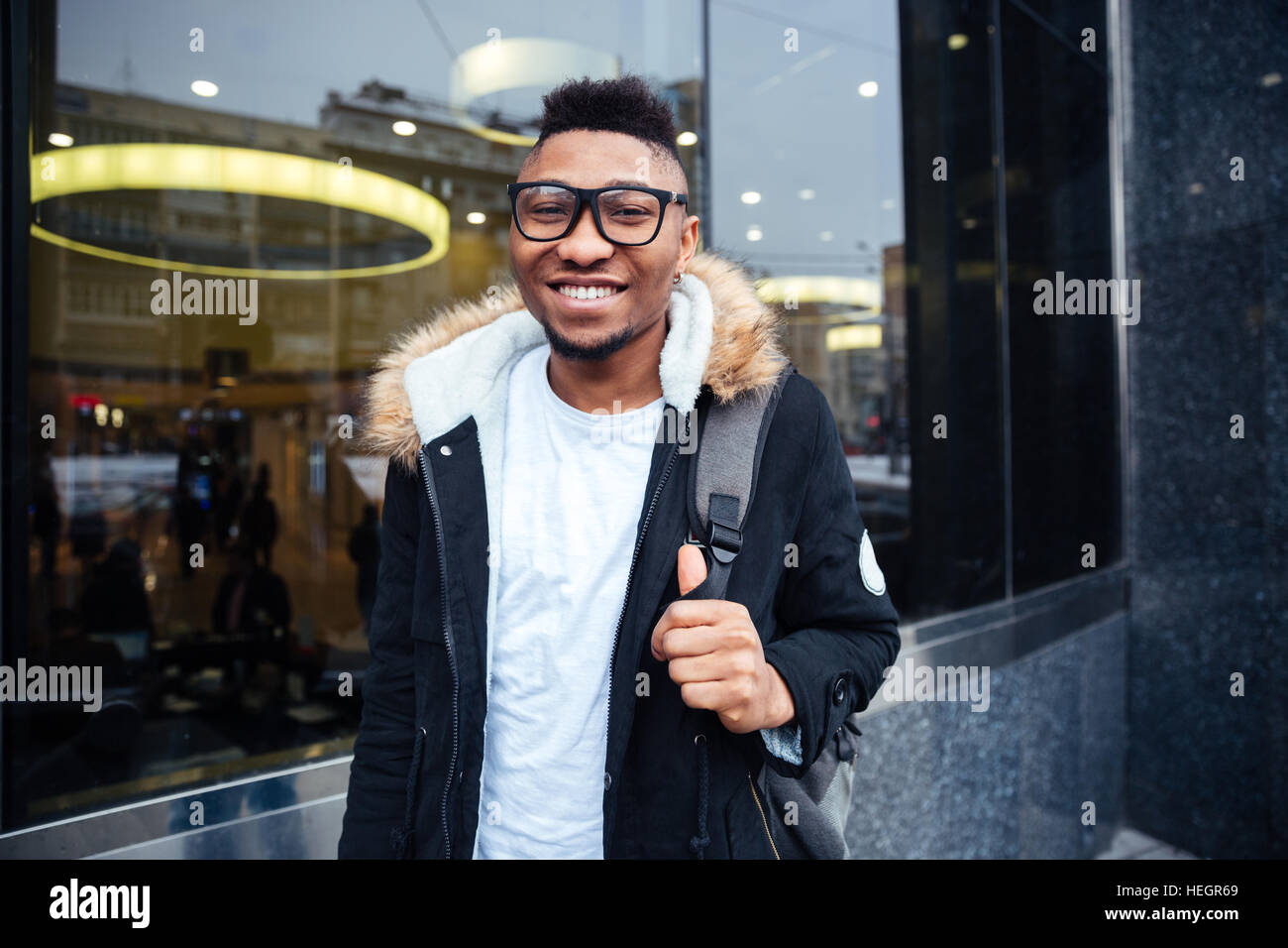 Portrait of a cheerful african young man walking on the street. Looking ...