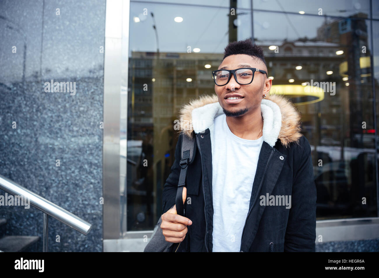Image of a cheerful african young man walking on the street. Looking ...