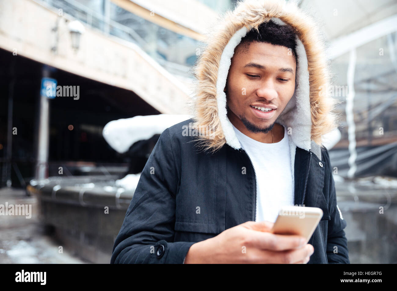 Picture of a handsome african young man walking on the street while ...