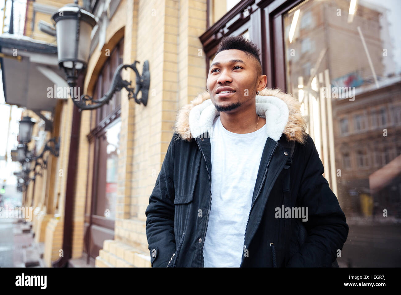 Picture of a handsome african young man walking on the street. Looking ...