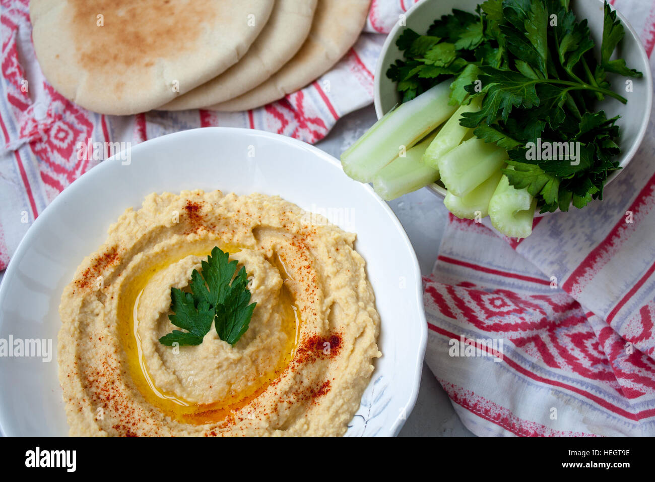 Home classic hummus with celery, pita. View top on gray concrete ...