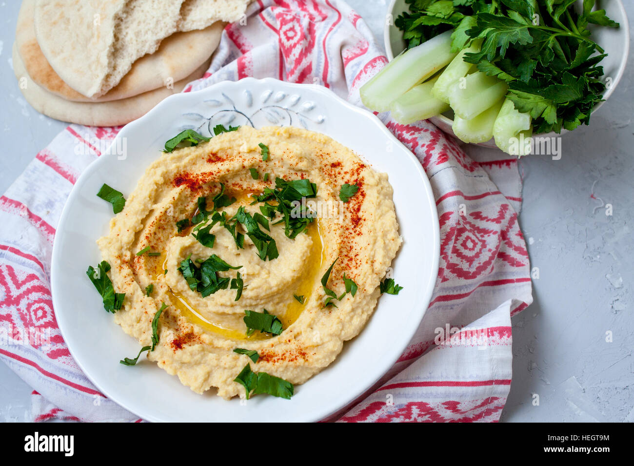 Home classic hummus with celery, pita. View top on gray concrete ...