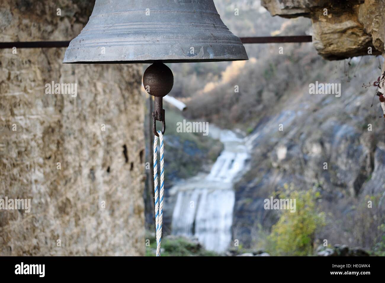 A photo of a bell in front of a waterfall Stock Photo - Alamy