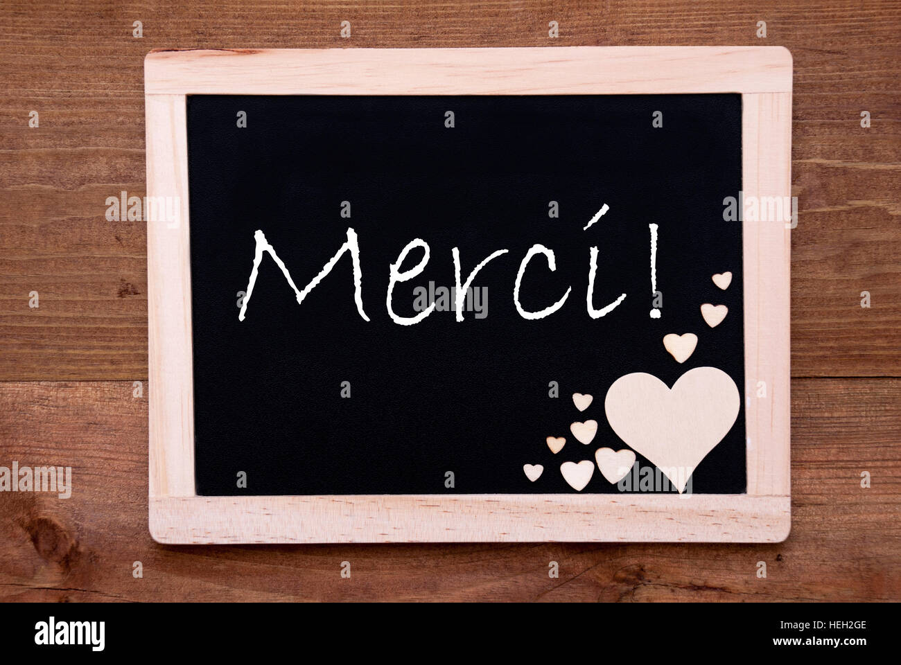 Blackboard With Wooden Hearts, Text Merci Means Thank You Stock Photo ...