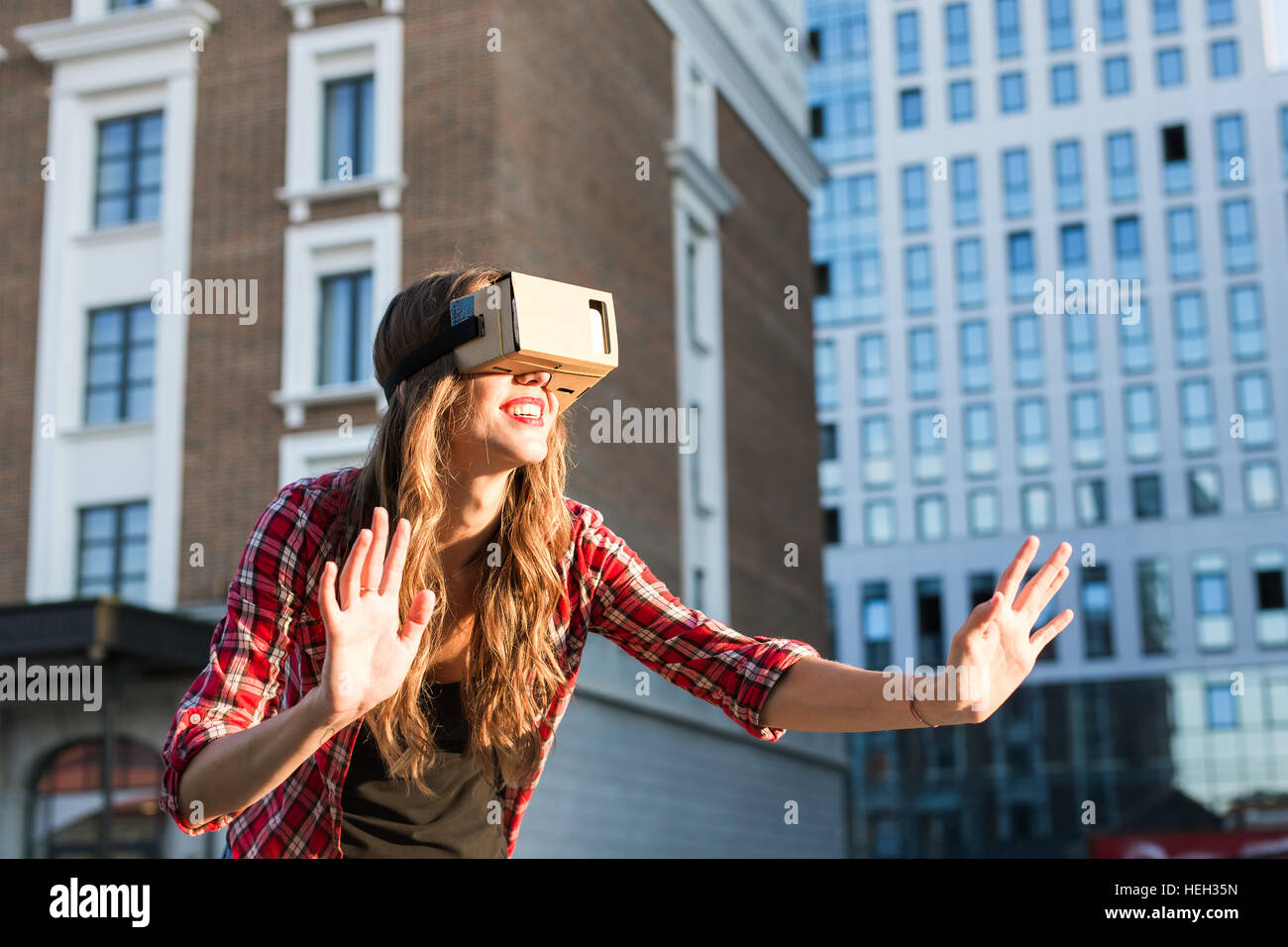 Beautiful young woman wearing virtual reality headset in an urban ...