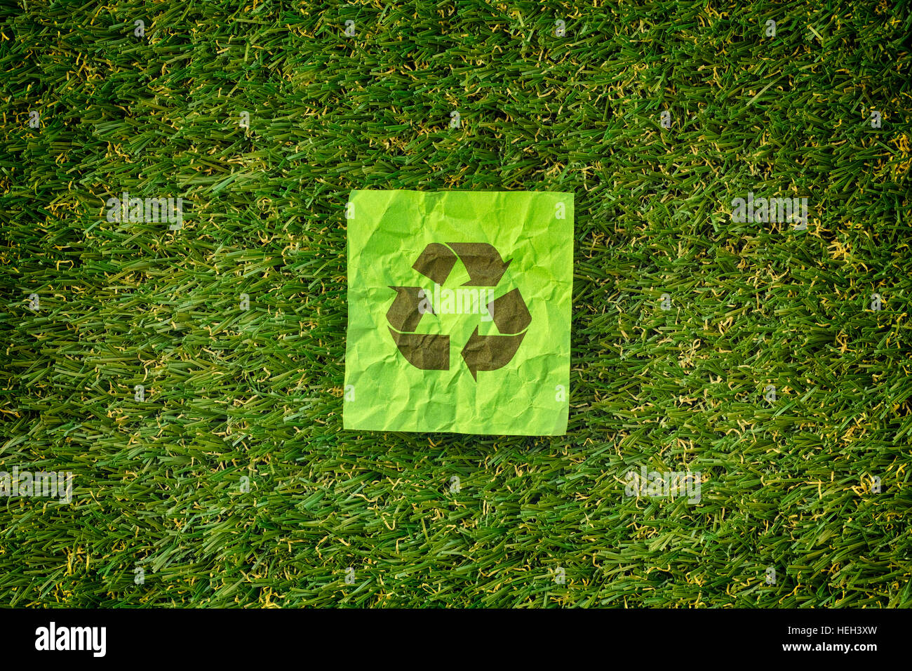 Recycle symbol laying on a green grass. Concept image Stock Photo - Alamy