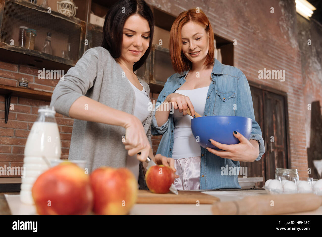 Positive delighted friends while cooking Stock Photo - Alamy