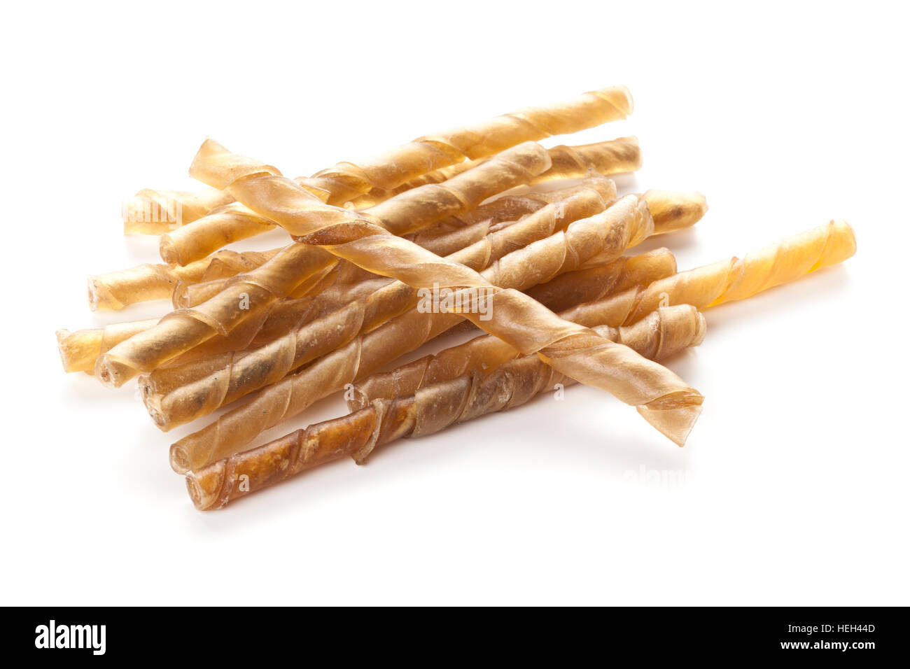 heap of cowhide chewing sticks for dogs isolated on white background ...