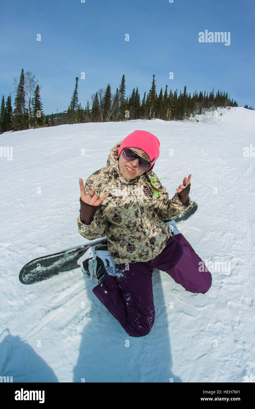 Smiling snowboarder girl near the snow mountain Stock Photo - Alamy